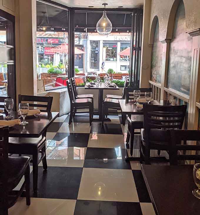 Black and white checkerboard floors, tall windows looking out onto Hanover Street, and tables set and waiting. The whole scene practically pulls you through the door.
