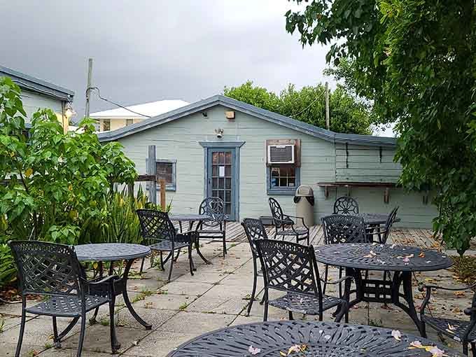 Wrought iron chairs, tropical greenery, and open skies above, outdoor dining here feels like a reward for showing up.