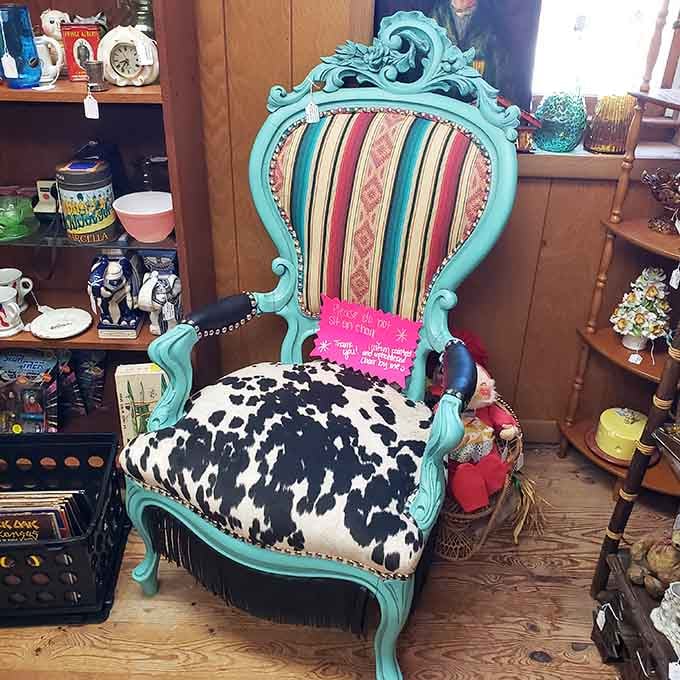 A turquoise Victorian chair with cowhide upholstery and a "please don't sit" sign, which is honestly fair enough.