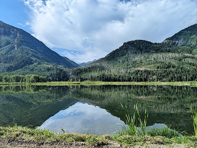 Mountain reflections mirror perfectly in still water, offering the kind of view that stops conversations mid-sentence.