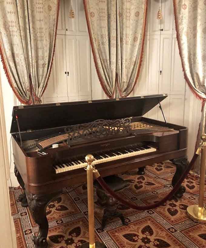 A grand piano tucked behind velvet ropes, proof that the Victorians understood how to make an entrance in any room.