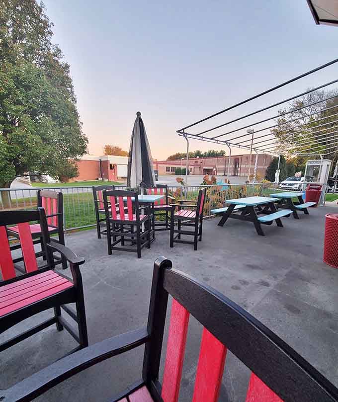 An outdoor patio with red and black chairs, because good weather deserves a good burger outside.