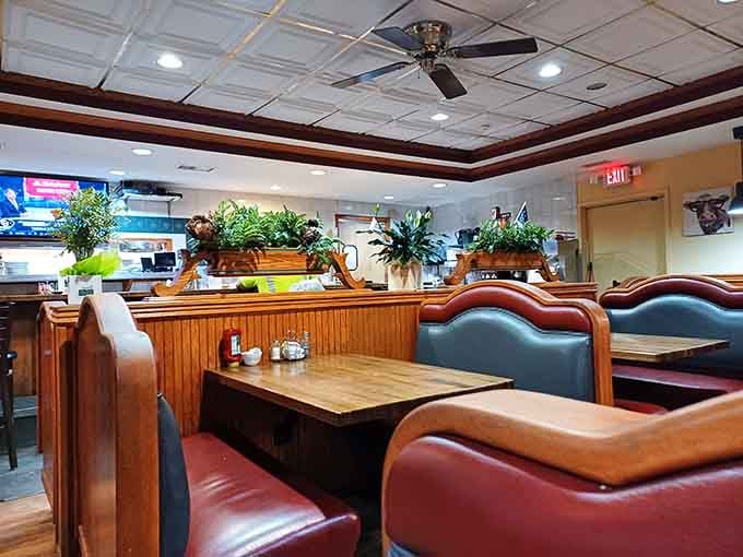 Deep red booths, live plants, and warm wood paneling, the kind of spot regulars guard like a secret.