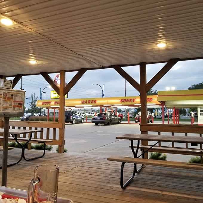 The covered patio at Dog n Suds offers a front-row seat to the drive-in action as evening settles in.