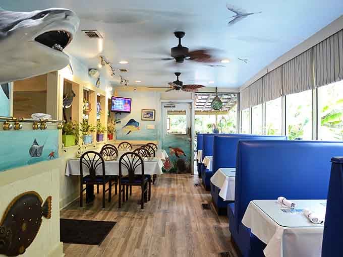 Soft lighting, white tablecloths, and a coastal mural wrapping the whole room. Dinner here feels like a mini vacation.