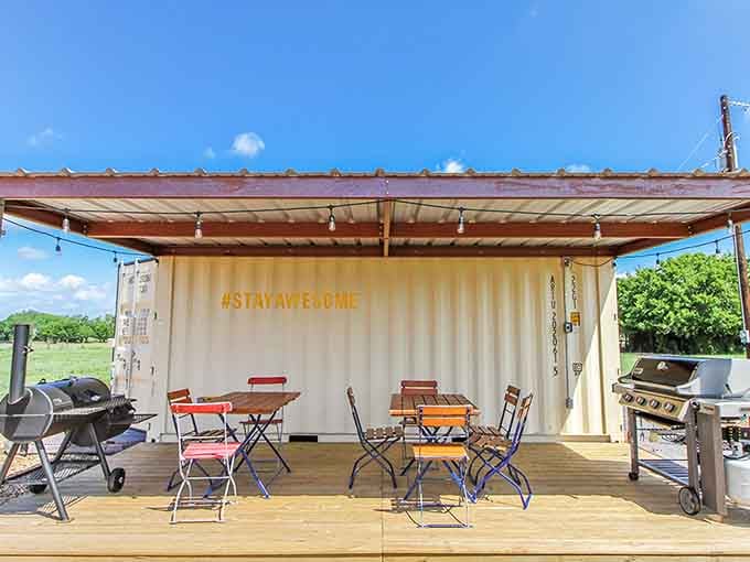 A smoker, a gas grill, bistro tables, and a wall that simply says "#STAYAWESOME." This outdoor kitchen is ready for a proper Texas cookout.