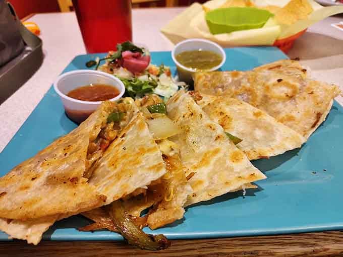 A fourteen-inch quesadilla arriving on a bright blue plate is the kind of sight that makes everyone at the table sit up straighter.