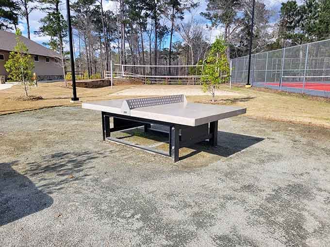 An outdoor ping pong table, a sand volleyball court, and a tennis court walk into a park. No punchline needed.