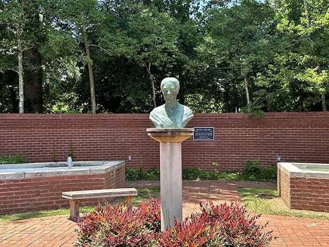 A bronze bust of Helen Keller stands in a quiet garden courtyard, serene and completely deserving of the spotlight.