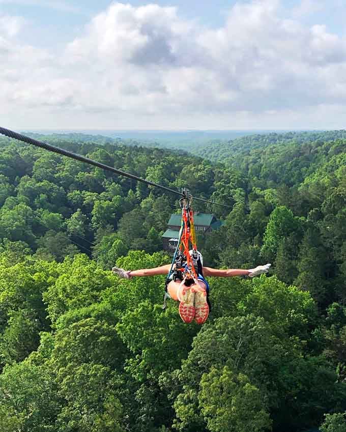 Full Superman mode activated, soaring face-down above the Georgia treetops with arms stretched wide open.
