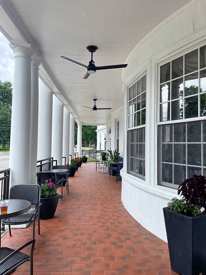 A long covered porch with ceiling fans turning lazily overhead, the kind of spot where time slows down on purpose.