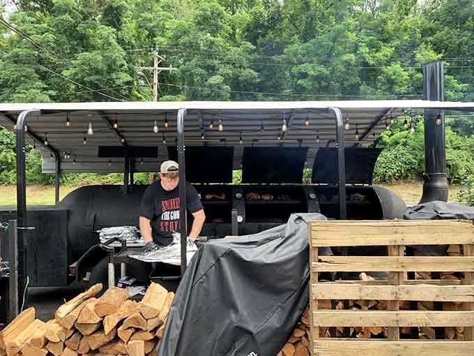 Stacks of real wood, a serious smoker, and one dedicated pitmaster. This is where the magic actually starts.