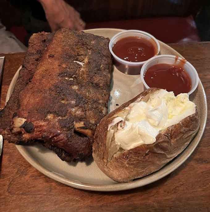 Baby back ribs with a bark so dark and beautiful it belongs in a museum. The baked potato beside it is no slouch either.