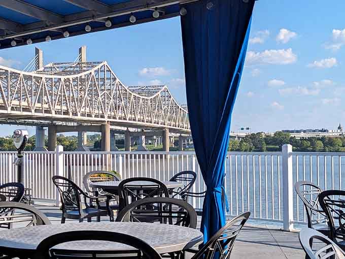 Outdoor seating with bridge views transforms an ordinary meal into a memorable riverside dining experience.