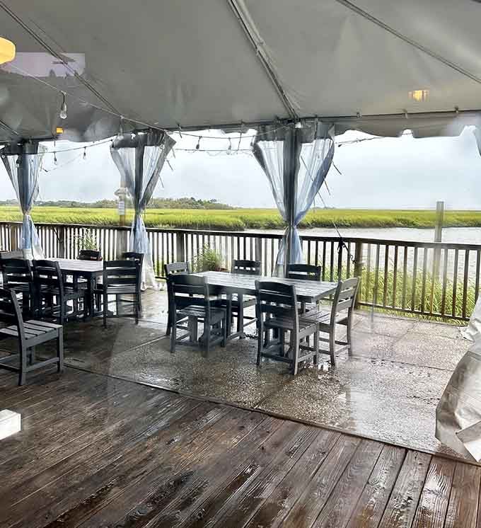 A covered waterfront deck with marsh grass stretching to the horizon. Rain or shine, this view delivers.