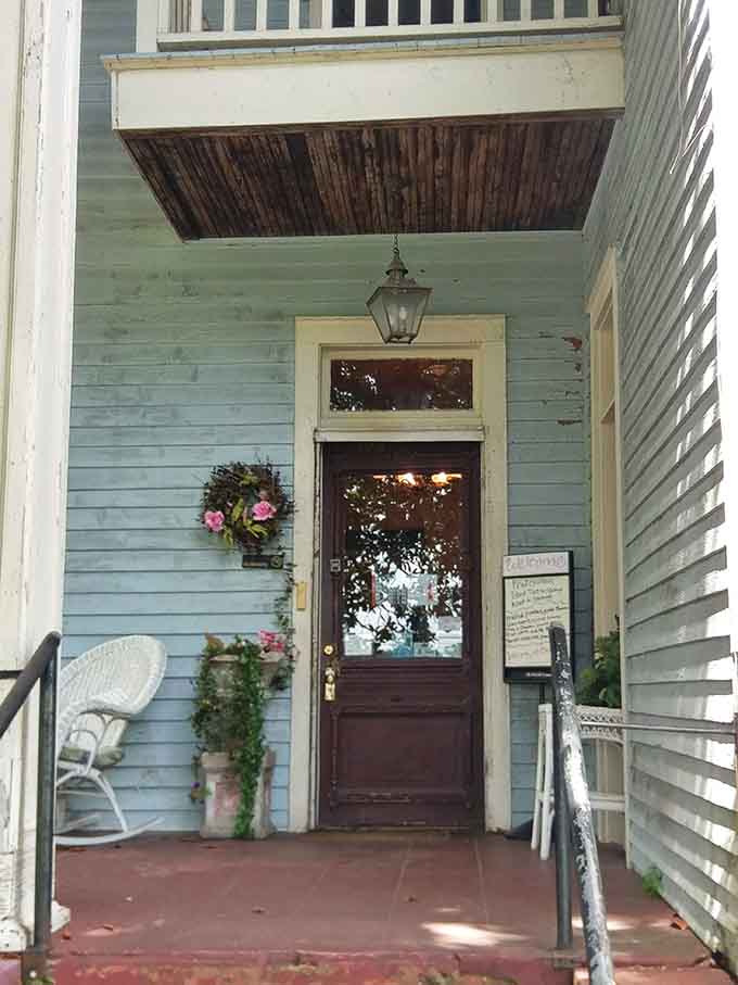 A wreath on the door, a lantern overhead, and a white wicker chair waiting, this entrance sets the tone perfectly.