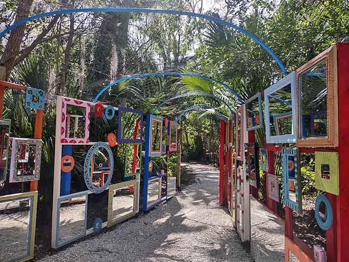 Colorful frames, mirrors, and arching metal overhead. This whimsical walkway is the garden's most unexpected surprise.