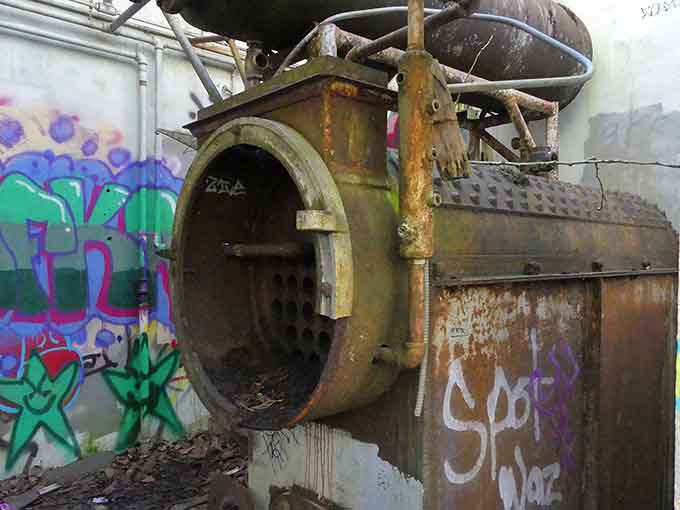 Rust, graffiti, and an old industrial autoclave create a scene that no interior decorator would ever willingly take credit for.