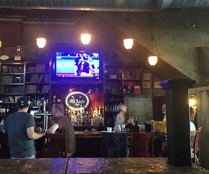 The Old Angle Tavern bar, glowing warmly under soft lights, with a sign that says you're in the right place.