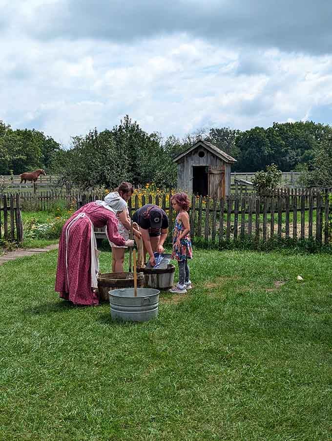 An interpreter shows visitors that laundry day in the 1800s was basically a full-body workout with no shortcuts.