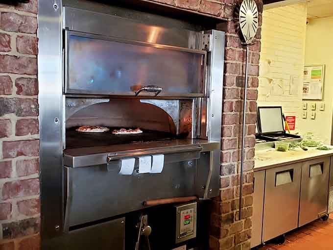 Pizzas sliding into a proper deck oven framed by exposed brick, this kitchen takes its craft seriously.