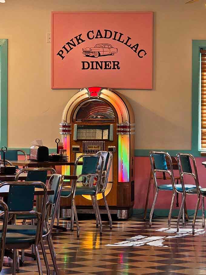 A glowing jukebox standing beneath the Pink Cadillac Diner sign, setting the mood before you even order.