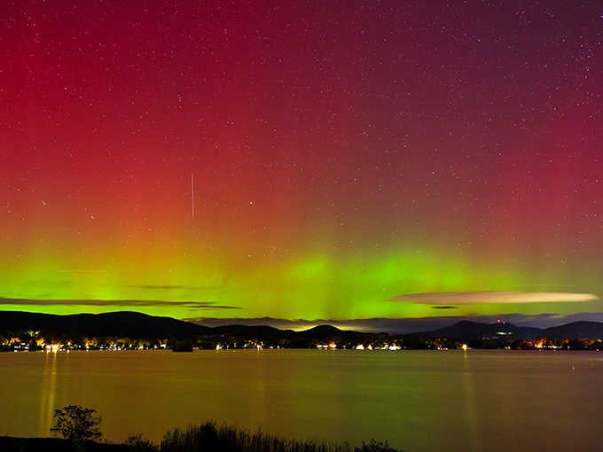 Northern lights dancing over Pontoosuc Lake in vivid green and red. Massachusetts just quietly pulled off something absolutely extraordinary.