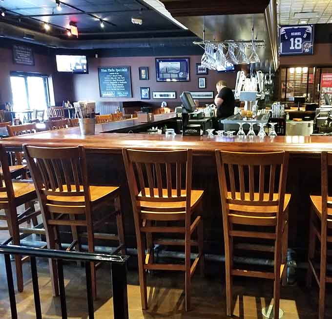 A long wooden bar, wine glasses hanging overhead, and a Peyton Manning jersey watching over everything. Very Indianapolis.