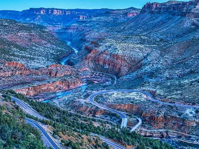 The highway hugs the canyon wall, switchbacks stacked like nature's own roller coaster designed for maximum scenic thrills.