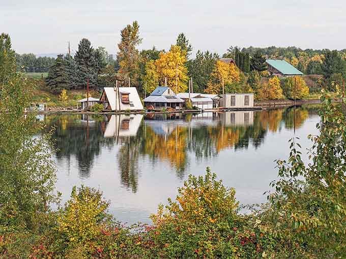 Floating homes nestle among autumn trees reflected in still water, a scene so lovely it almost seems fictional.