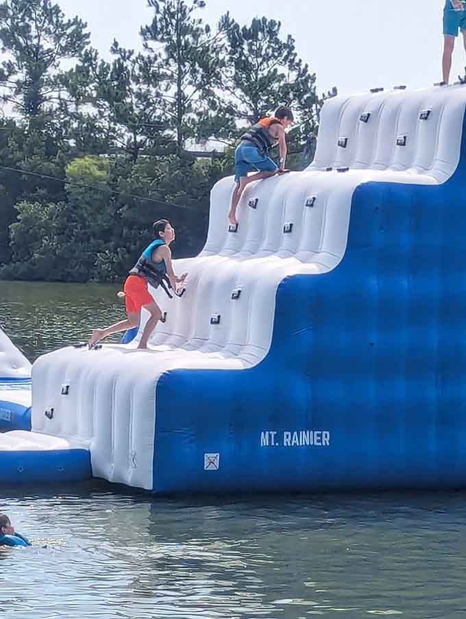 The climbing wall beckons climbers upward, though getting down usually involves less grace and more unplanned swimming.