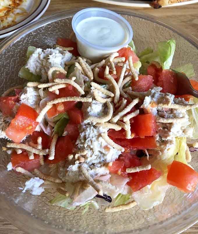 Fresh tuna salad piled high with crispy toppings, proving lunch here rivals their legendary breakfast offerings.