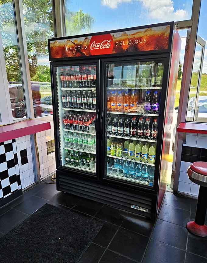 A fully stocked Coca-Cola cooler standing at attention, because a great meal deserves an equally great cold drink alongside it.