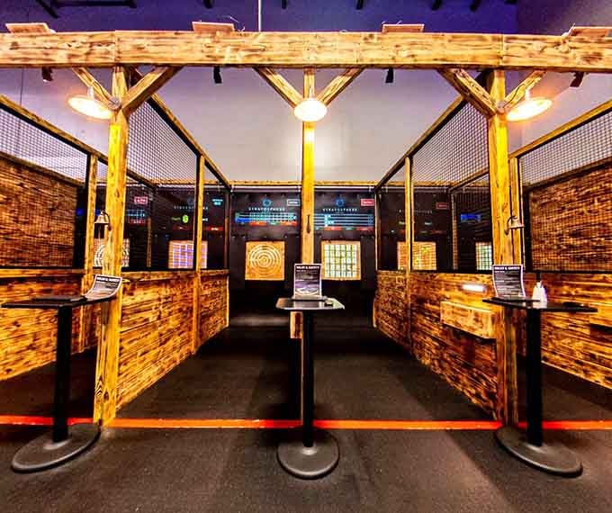 Axe throwing lanes framed in rustic wood, proof that sometimes the most satisfying things involve a little controlled chaos.