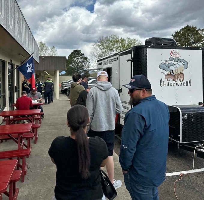The line stretches past the red outdoor tables. Good BBQ is always worth standing still for.