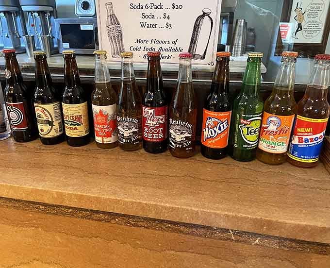 A lineup of vintage glass soda bottles that would make any serious collector weep with joy and thirst simultaneously.