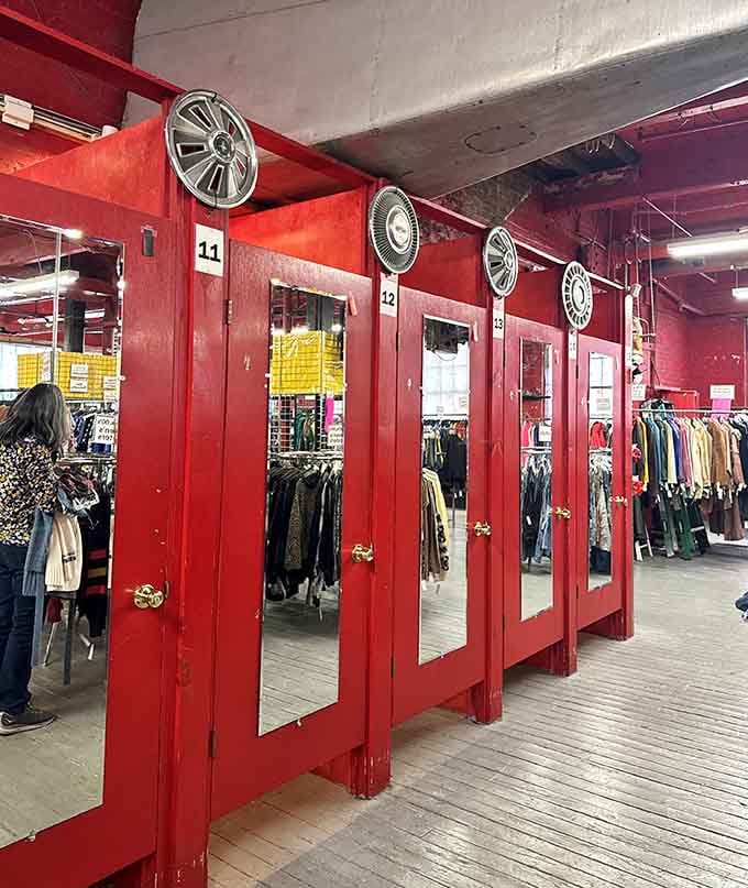 Red fitting room doors with hubcap decorations prove that even trying on clothes here is part of the quirky adventure.