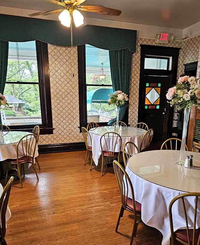 A stained glass door panel, patterned wallpaper, tall windows, and fresh floral arrangements, this dining room has more personality than most people do.