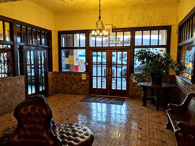Tufted leather chairs, warm chandelier light, and original tile floors greet you the moment you step inside.