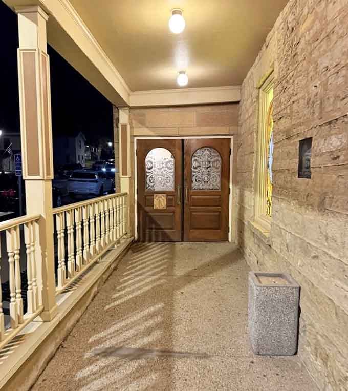 The entrance porch at twilight, where limestone meets wooden railings and history greets every single arriving guest with style.