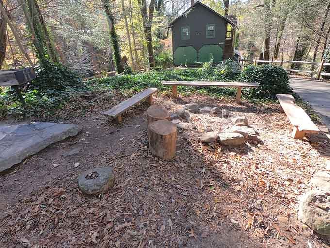 A fire pit, log benches, and a little green outbuilding watching over it all. Ghost stories optional but strongly encouraged.