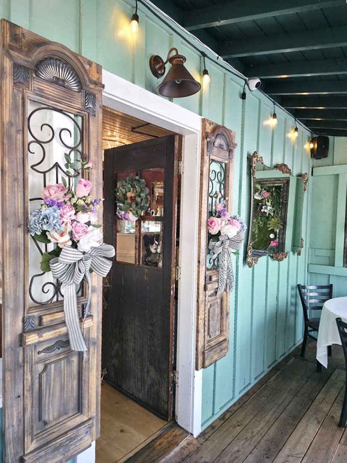 That weathered door with floral wreaths promises something magical waiting just beyond the threshold inside.