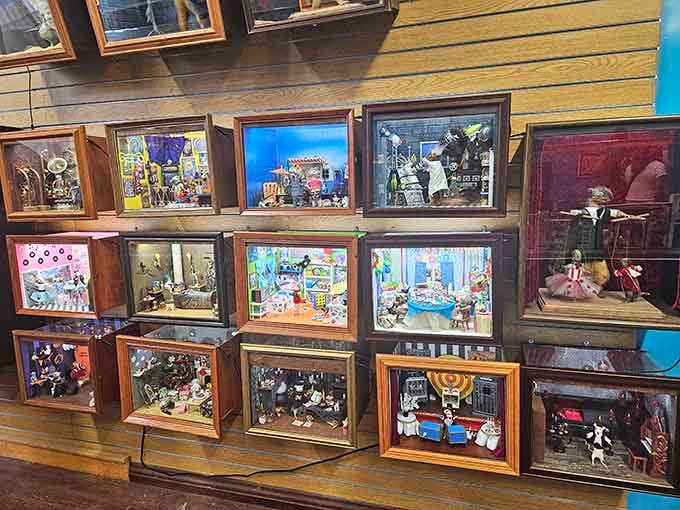 An entire wall of illuminated shadowbox dioramas, each one its own tiny universe packed with personality and surprises.