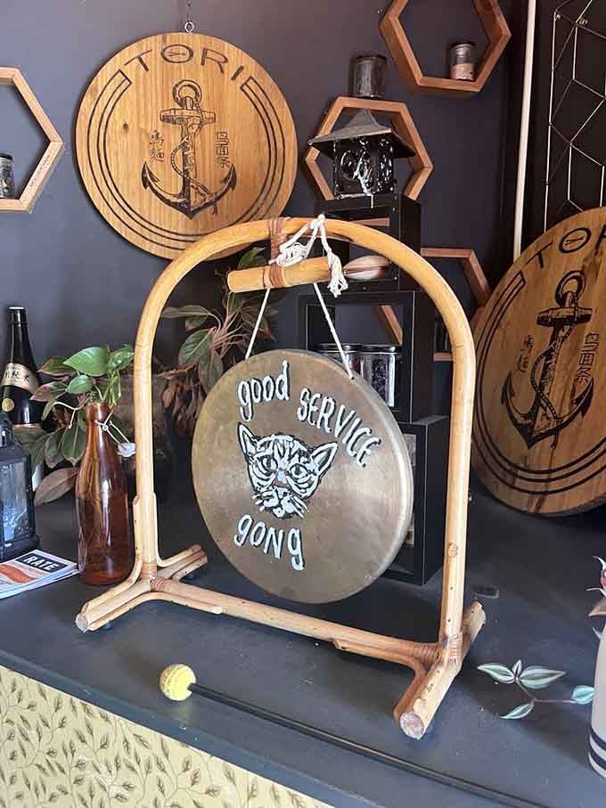 A brass gong labeled "good service gong" sitting next to the Tori anchor logo. Yes, this place is exactly as fun as it looks.