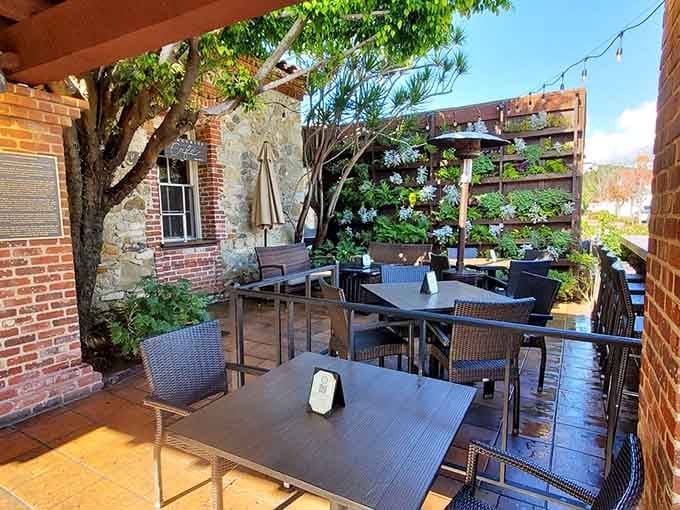 A sun-dappled patio tucked against stone walls and blooming plants. Outdoor dining in San Juan Capistrano doesn't get more charming.