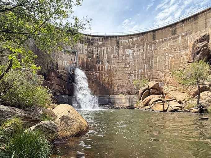 Water spills down the face of the Watson Lake dam into a rocky pool below. Unexpectedly dramatic.