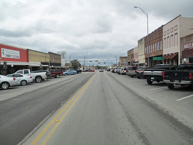 Bowie's main street stretches wide under a dramatic cloudy sky, with pickup trucks parked like they own the place.
