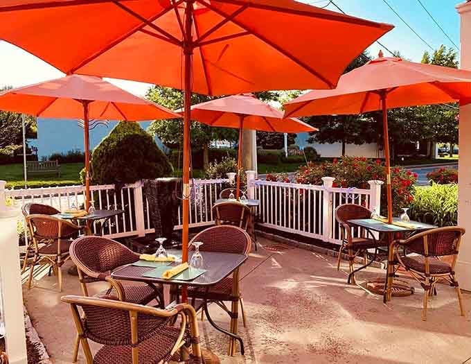 Burnt-orange umbrellas, wicker chairs, and rose bushes lining the fence, this patio is where Connecticut afternoons belong.