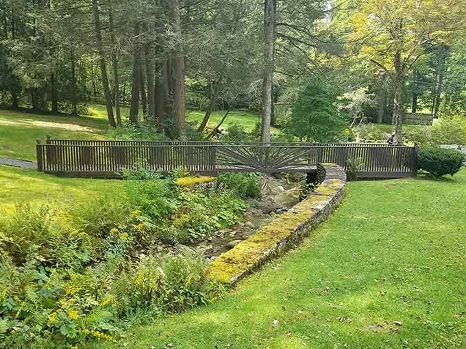 A wooden footbridge arching over a mossy stream, the sort of charming detail that makes you feel like you've wandered into a storybook.