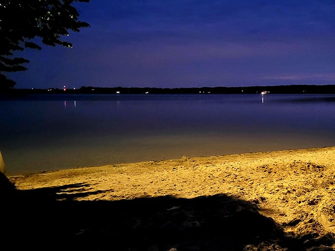 Evening transforms the beach into something magical, where sand glows golden under artificial light like treasure.